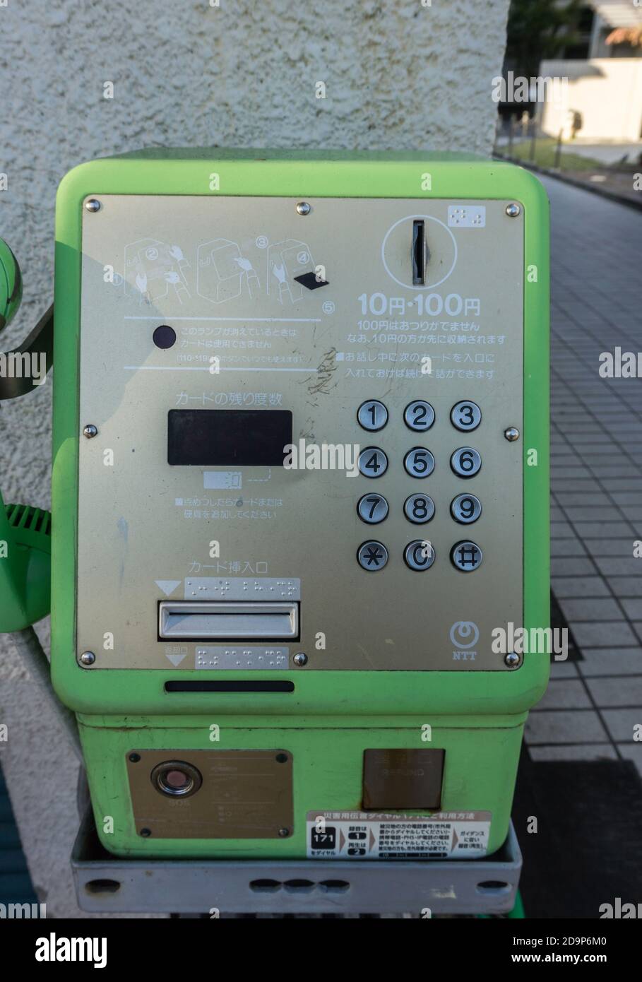 Old fashioned green Japanese NTT public telephone in a street in Kyoto ...