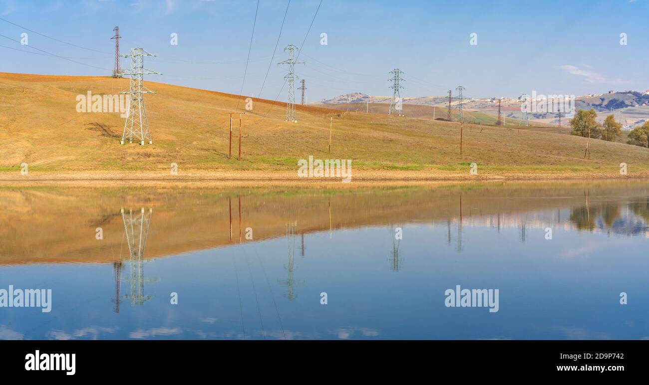 Power transmission towers in a mountain valley by the lake Stock Photo ...