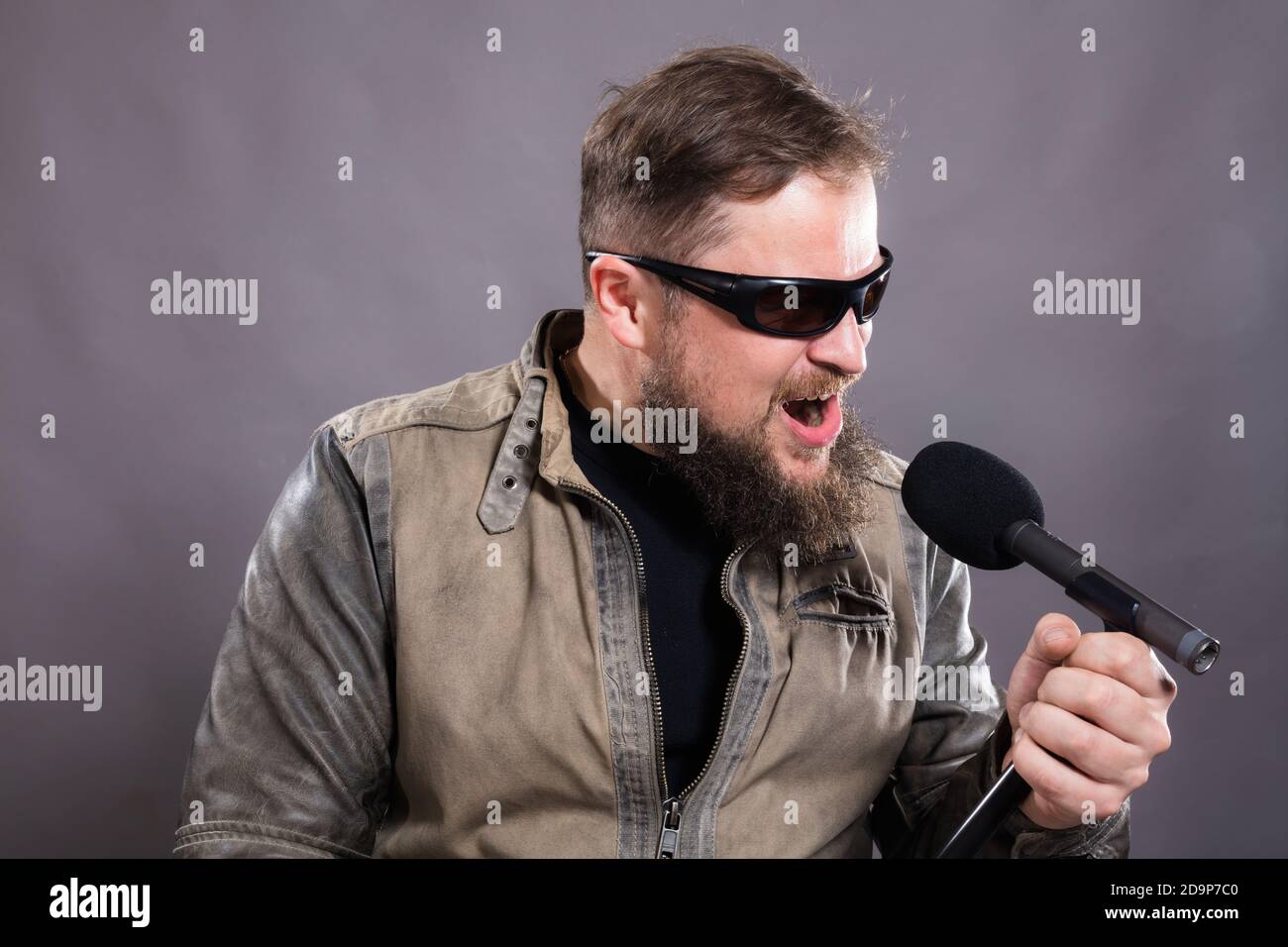 Bearded emotional rock singer with micriphone studio portrait Stock ...
