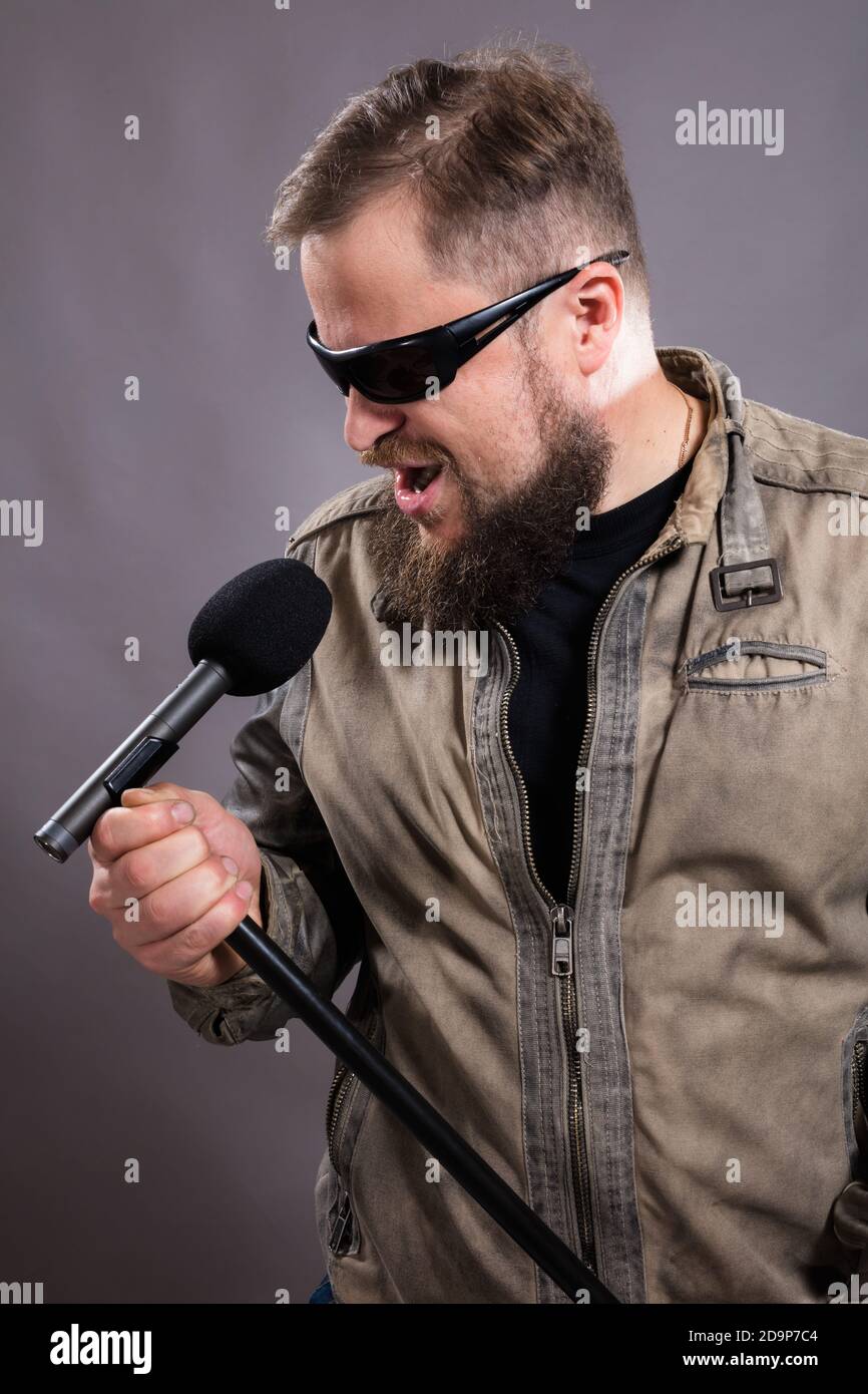Bearded emotional rock singer with micriphone studio portrait Stock ...