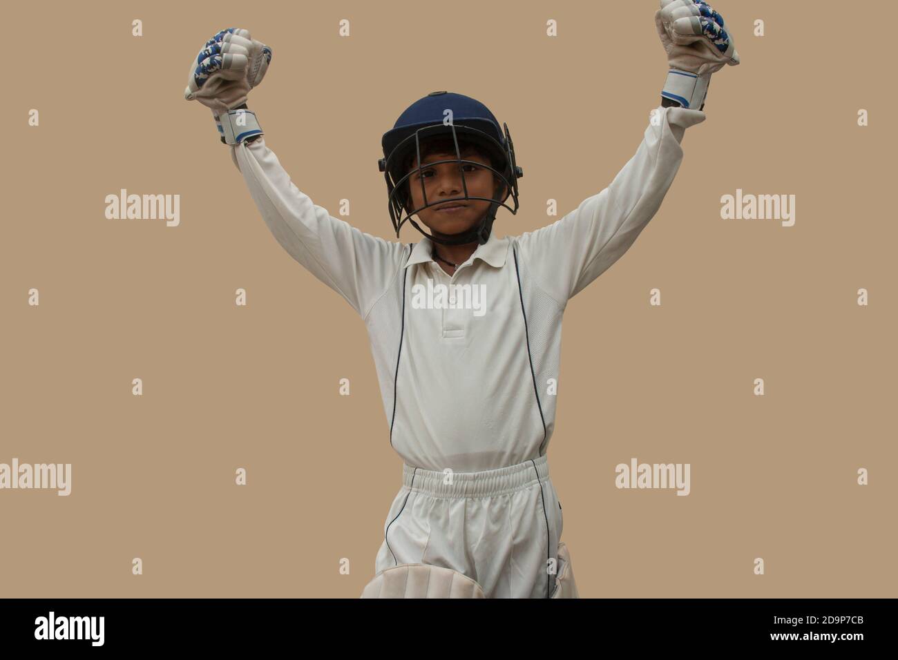 A boy in cricket uniform waving his arms in celebration Stock Photo - Alamy