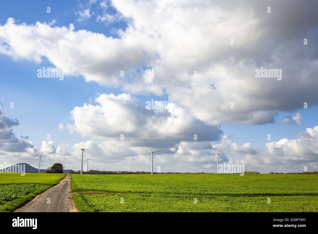 Heavily clouded sky over a cultivated field with windmills for electric ...