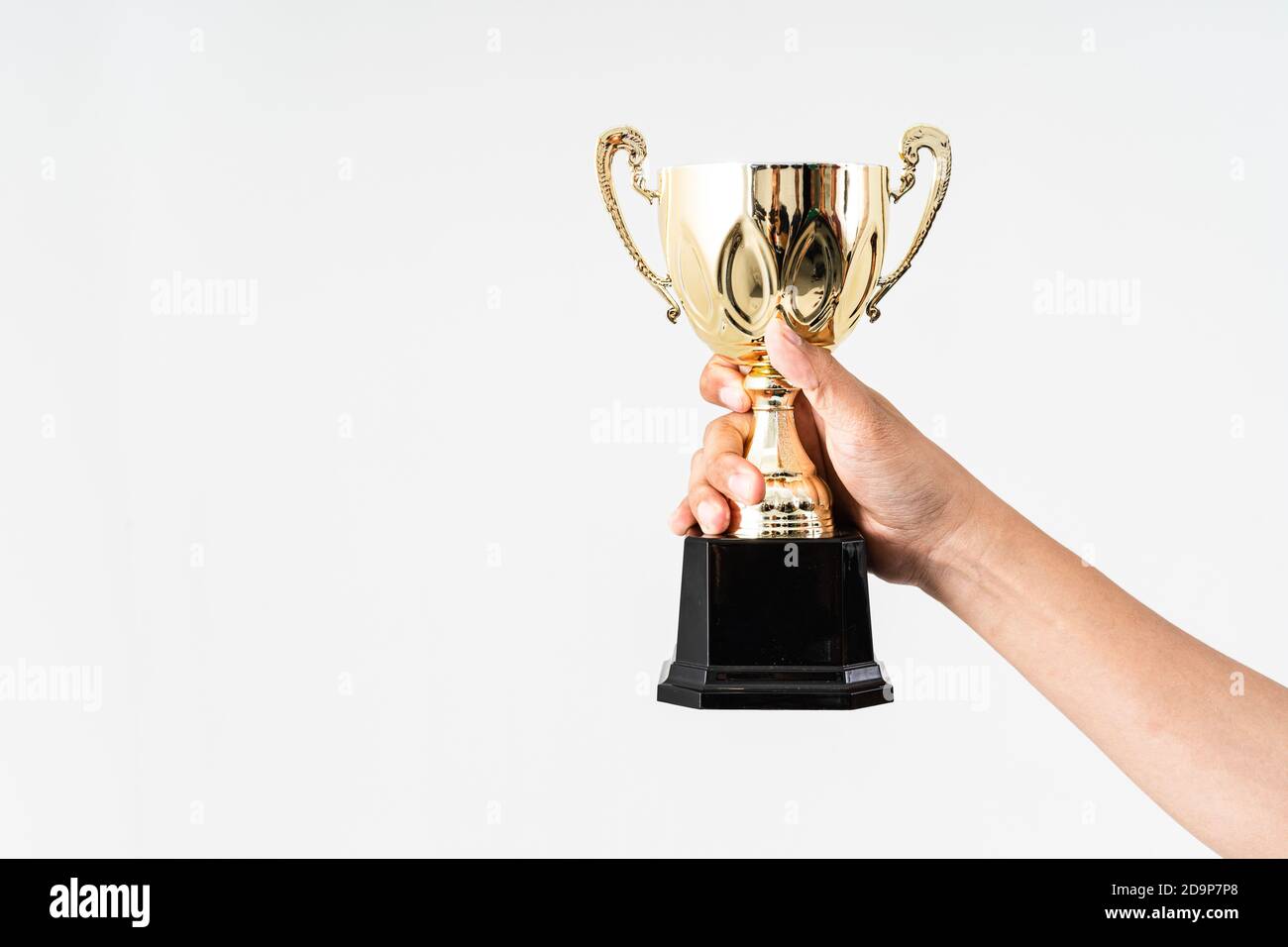 A man’s hand holding a trophy against isolated white background Stock ...