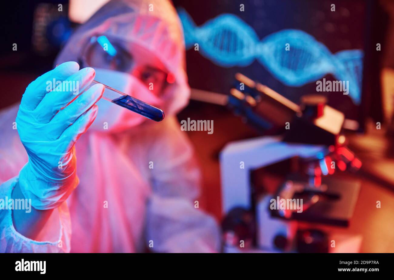 Nurse in mask and white uniform, holding tube with liquid and sitting ...