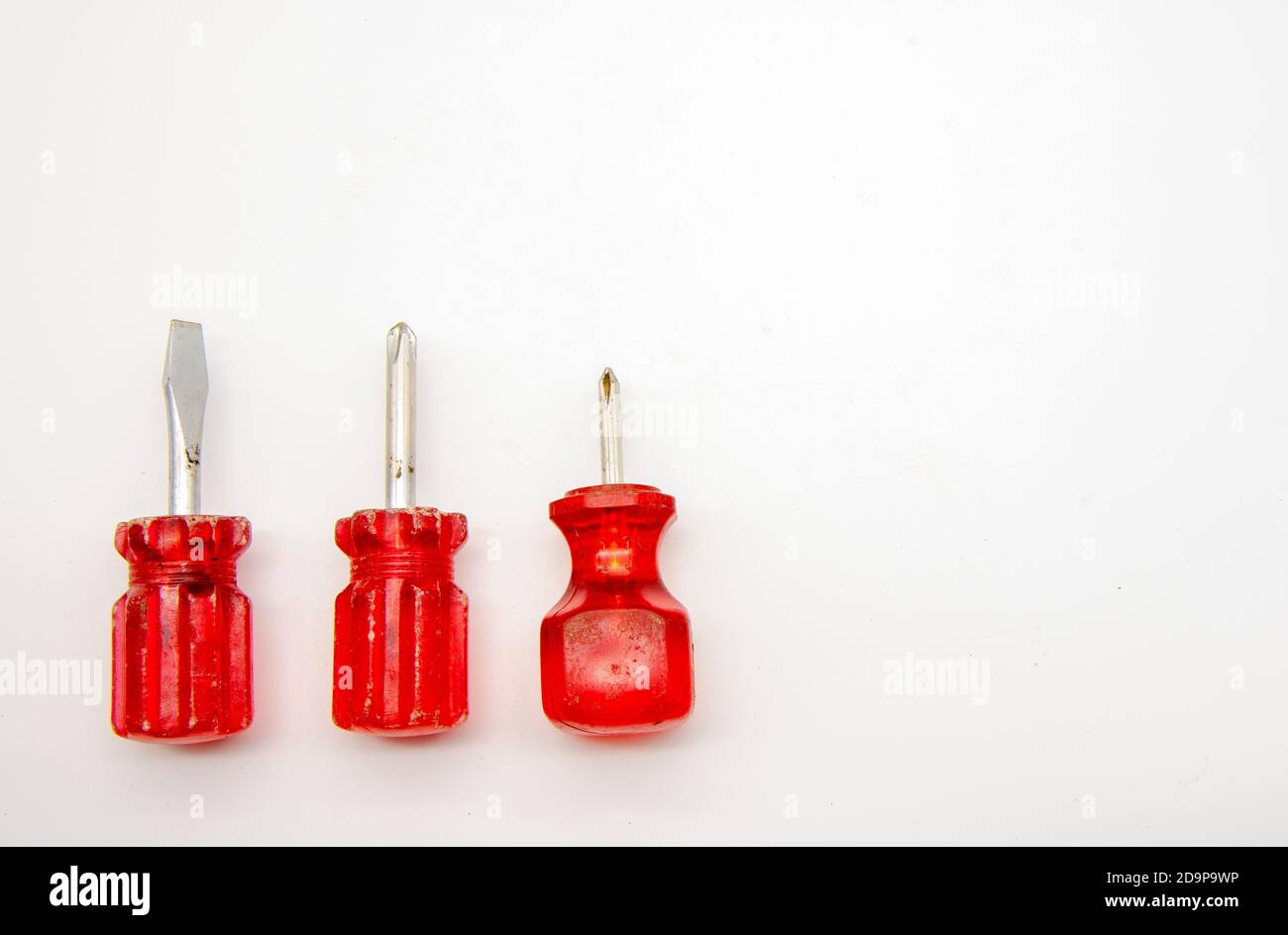Three small screwdrivers with red handles on a white background Stock ...