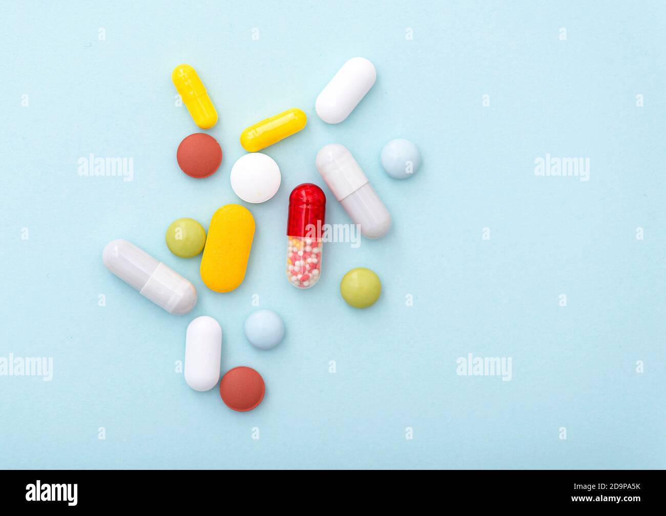 Medical composition. Some colour pills on blue background, top view ...