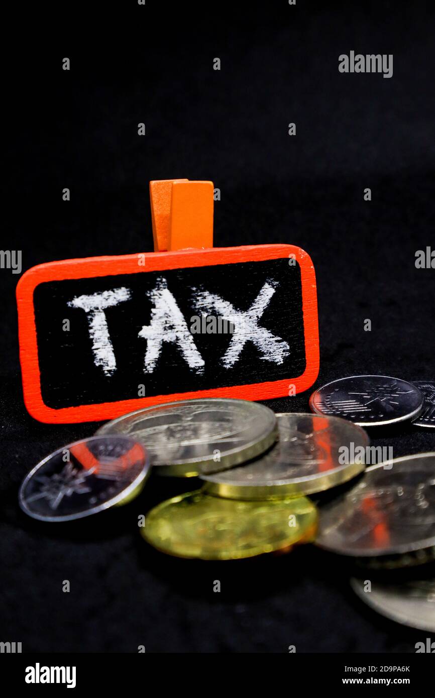 “TAX” wording on a stack of coins, isolated Stock Photo - Alamy