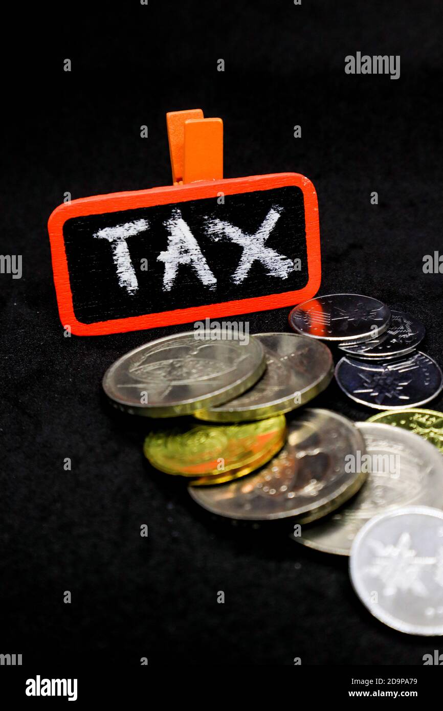 “TAX” wording on a stack of coins, isolated Stock Photo - Alamy