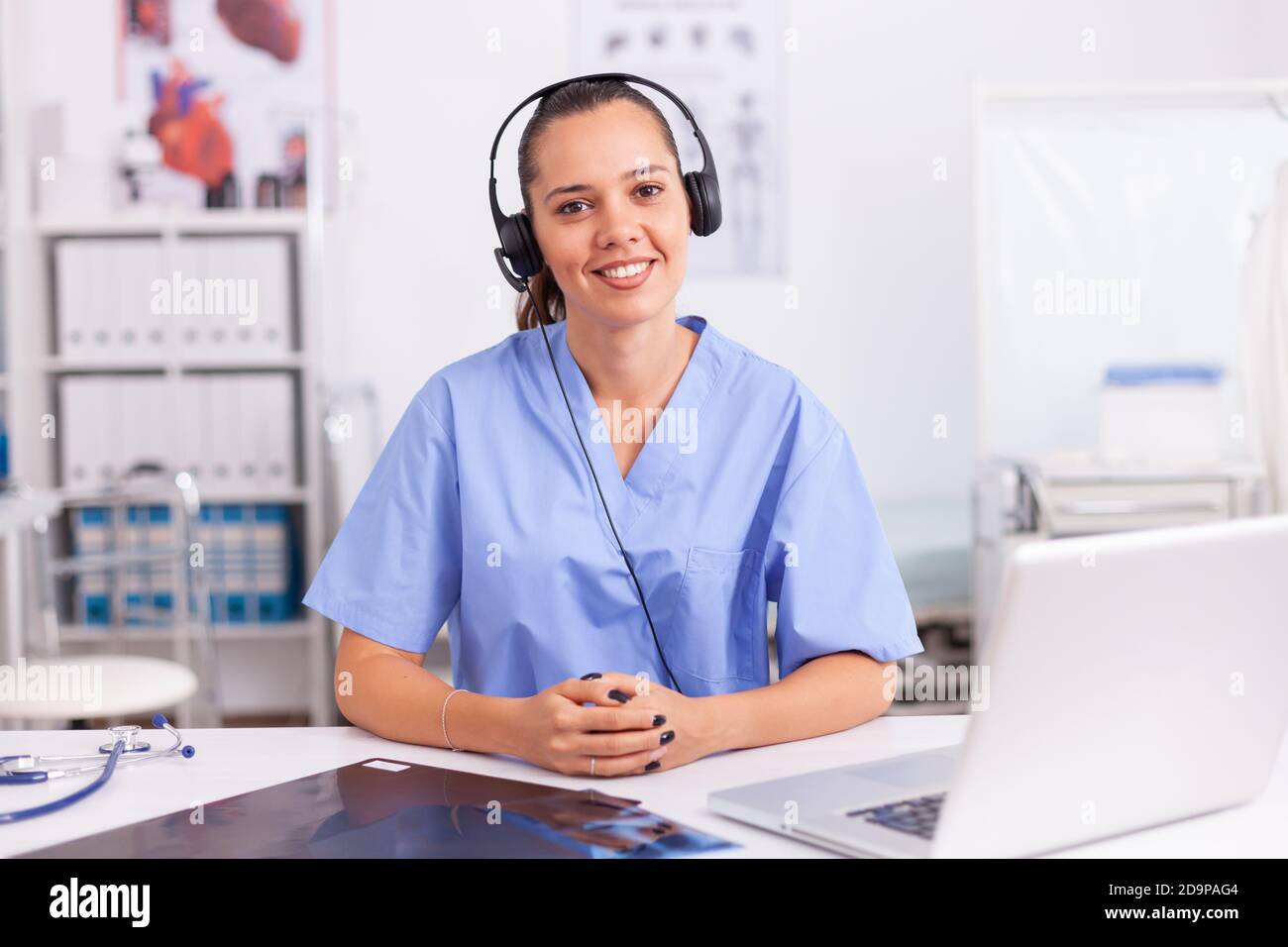 Young practitioner doctor working at the clinic reception desk talking ...