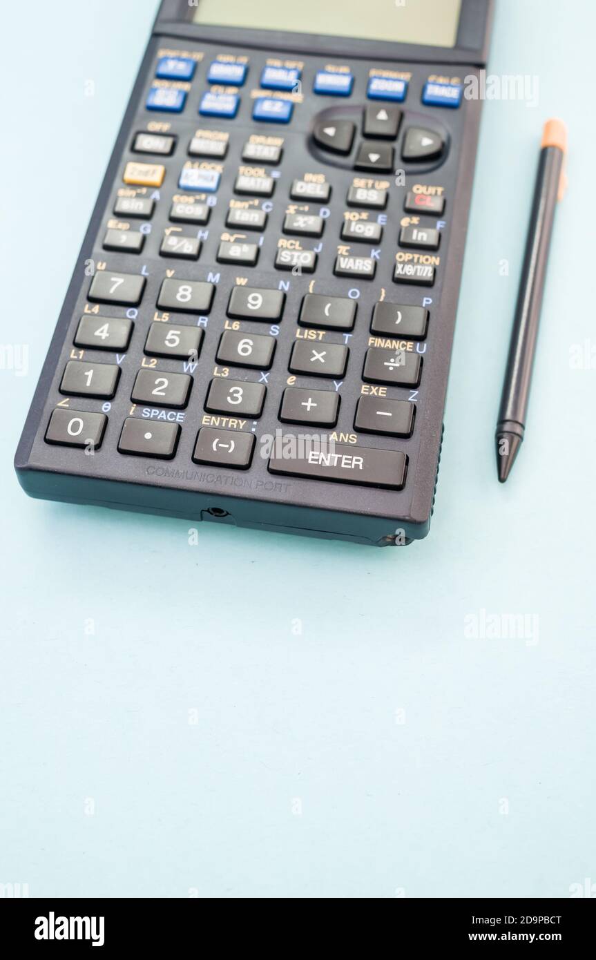 Vertical shot of a calculator and a pen on a blue background Stock ...