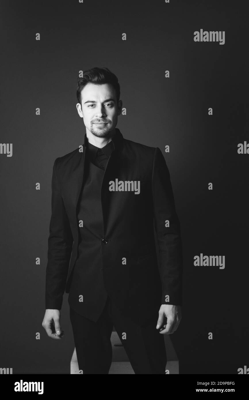 Studio portrait of a young caucasian man in a black blazer, looking at ...