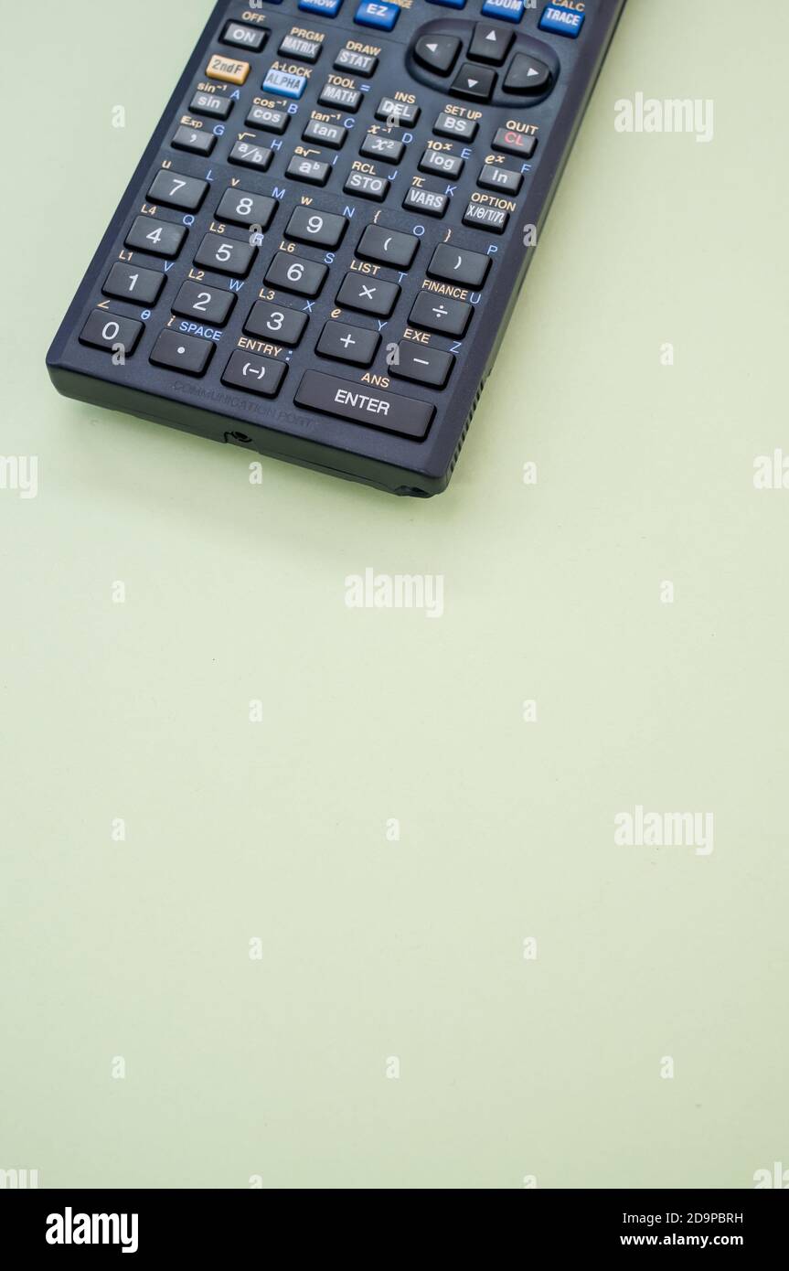 Vertical shot of a calculator on a green background Stock Photo - Alamy