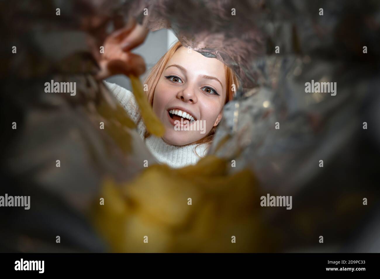 beautiful emotional girl teenager takes chips from the package and is ...