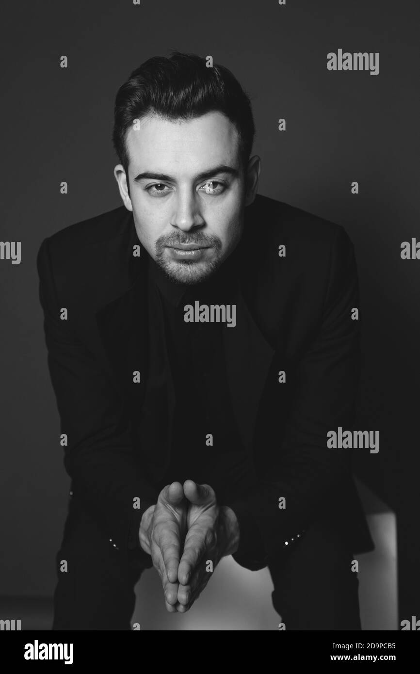 Studio portrait of a young caucasian man in a black jacket, seriously ...