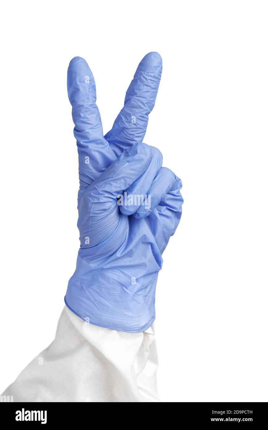 A human hand with two fingers up in a blue medical glove gestures a ...