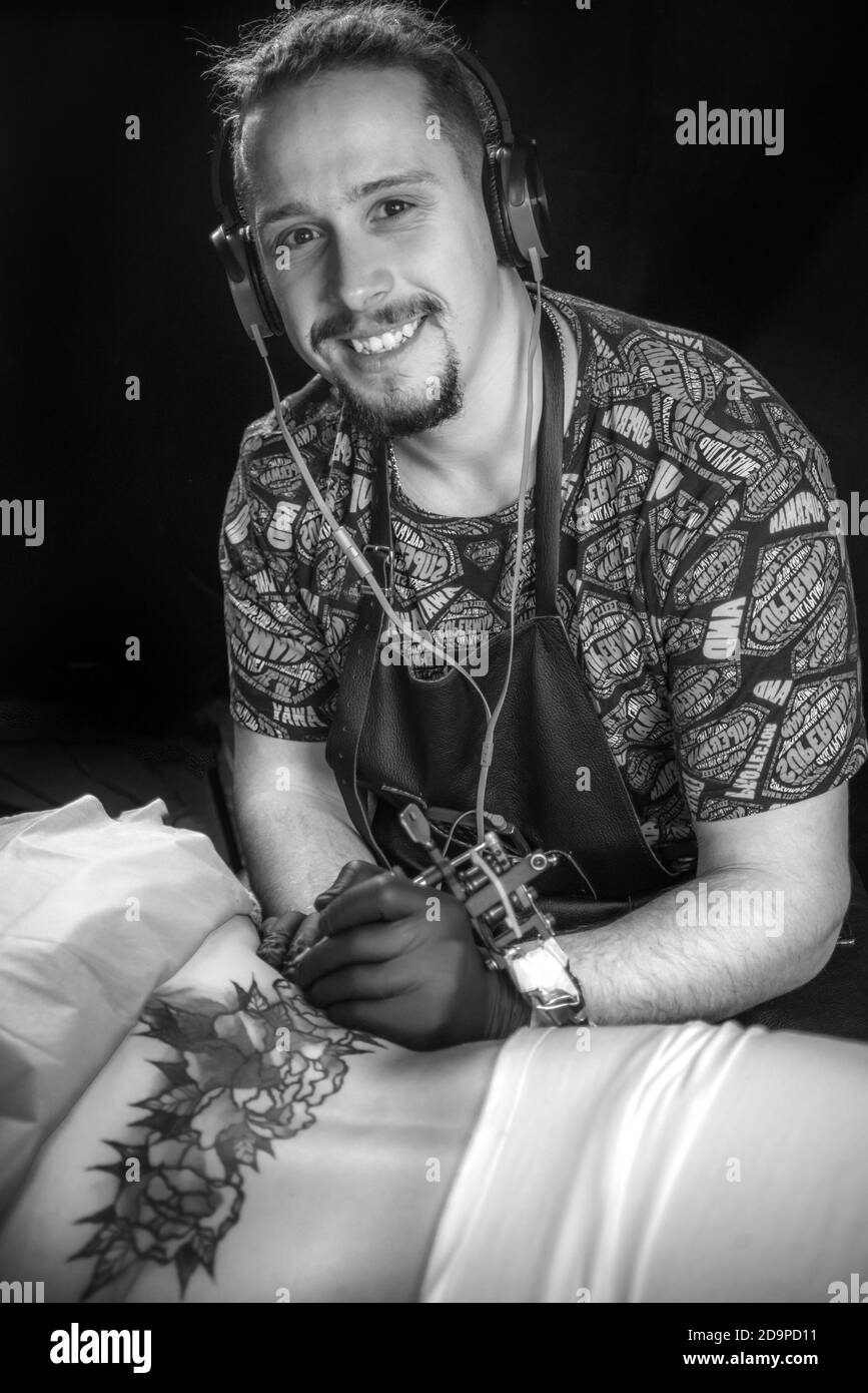 Tattooer makes tattoo art tattoo studio Stock Photo - Alamy