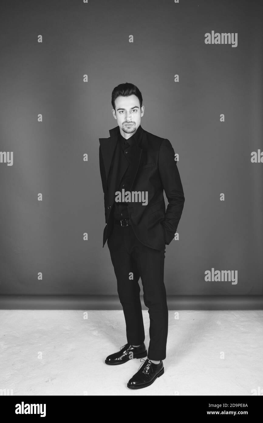 Studio portrait of a young caucasian man in a black blazer, looking at ...