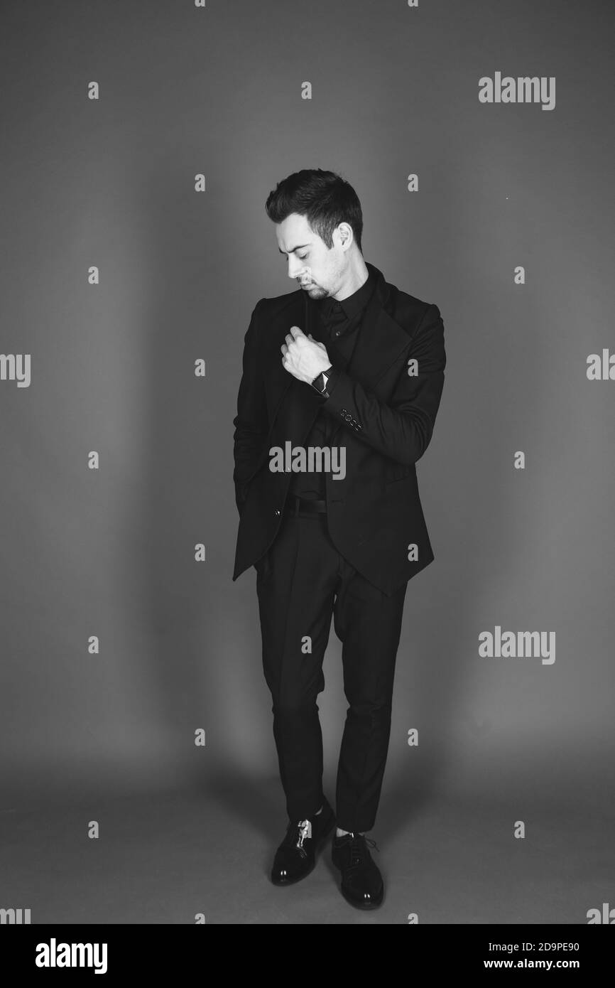 Studio portrait of a young caucasian man in a black blazer, looking ...