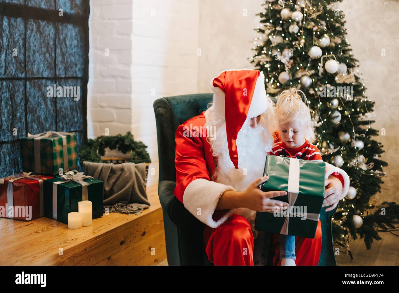 Kind Santa Claus giving gift box to little girl Stock Photo - Alamy