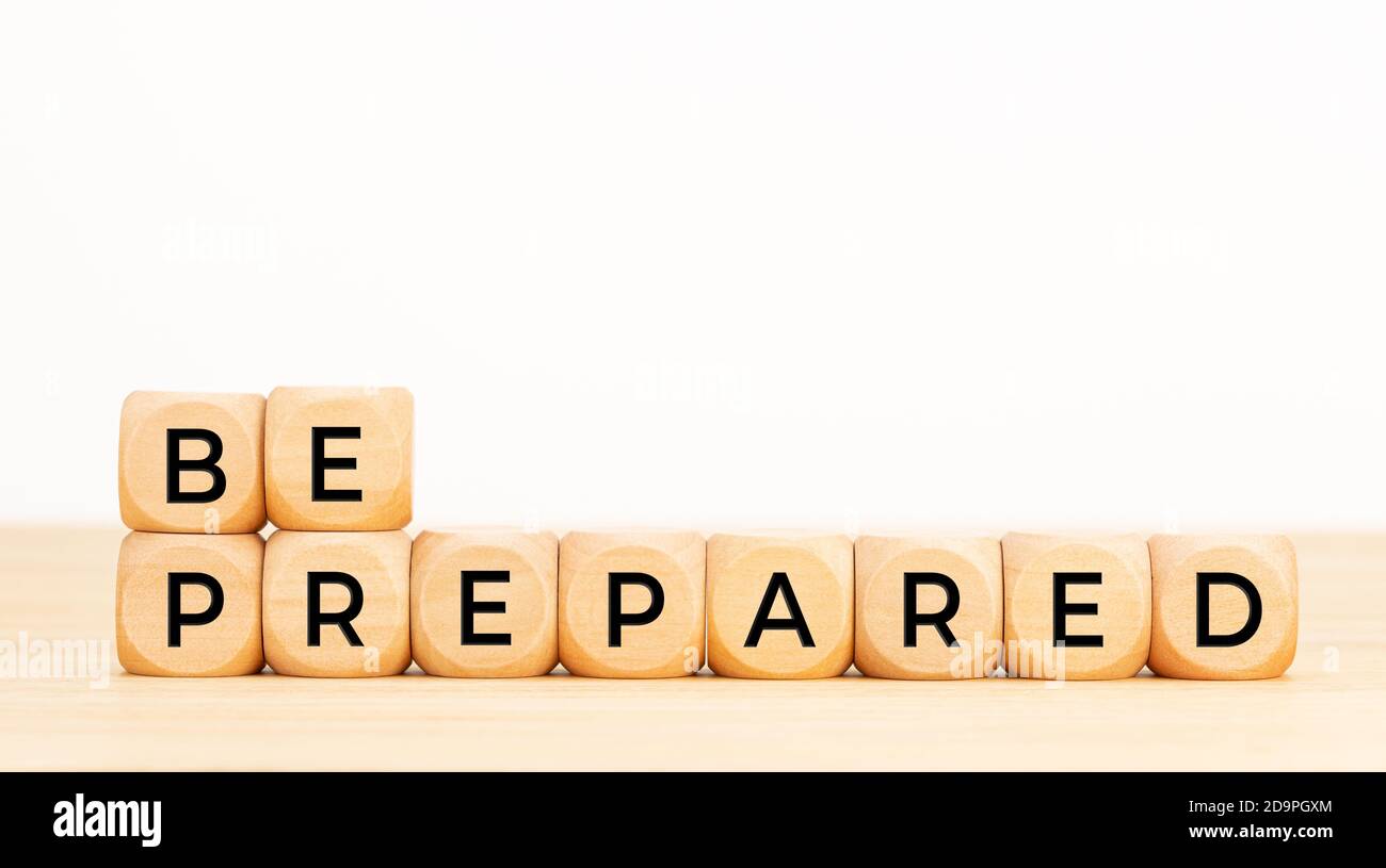 Be prepared phrase in wooden blocks on table. White background. Copy ...