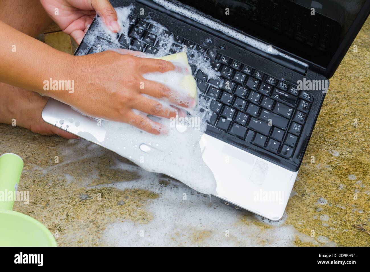 closeup cleaning computer notebook with dish washing soap, technology ...