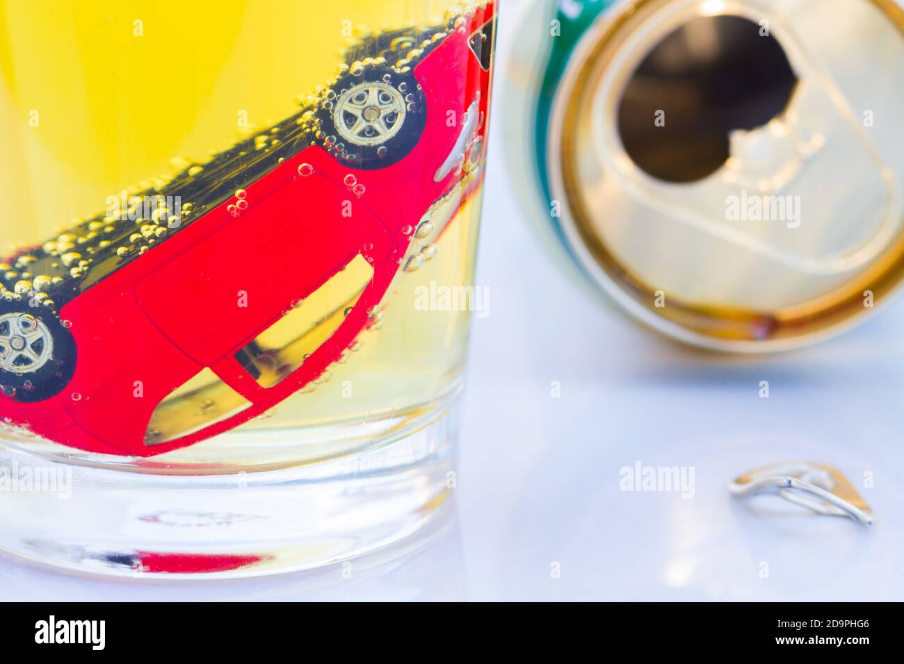 horizontal photo of red toy car in a glass of beer isolated on white ...