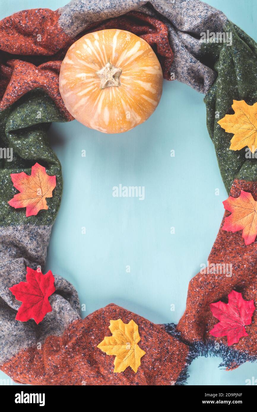 Cozy red and green scarf with autumn leaves on turquoise background ...