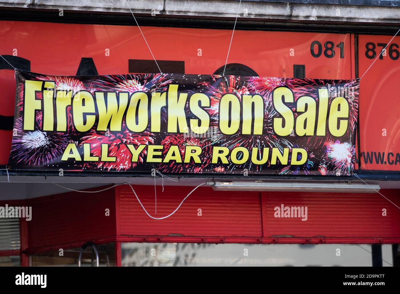 A temporary banner over a shop sign advertising year-round fireworks ...