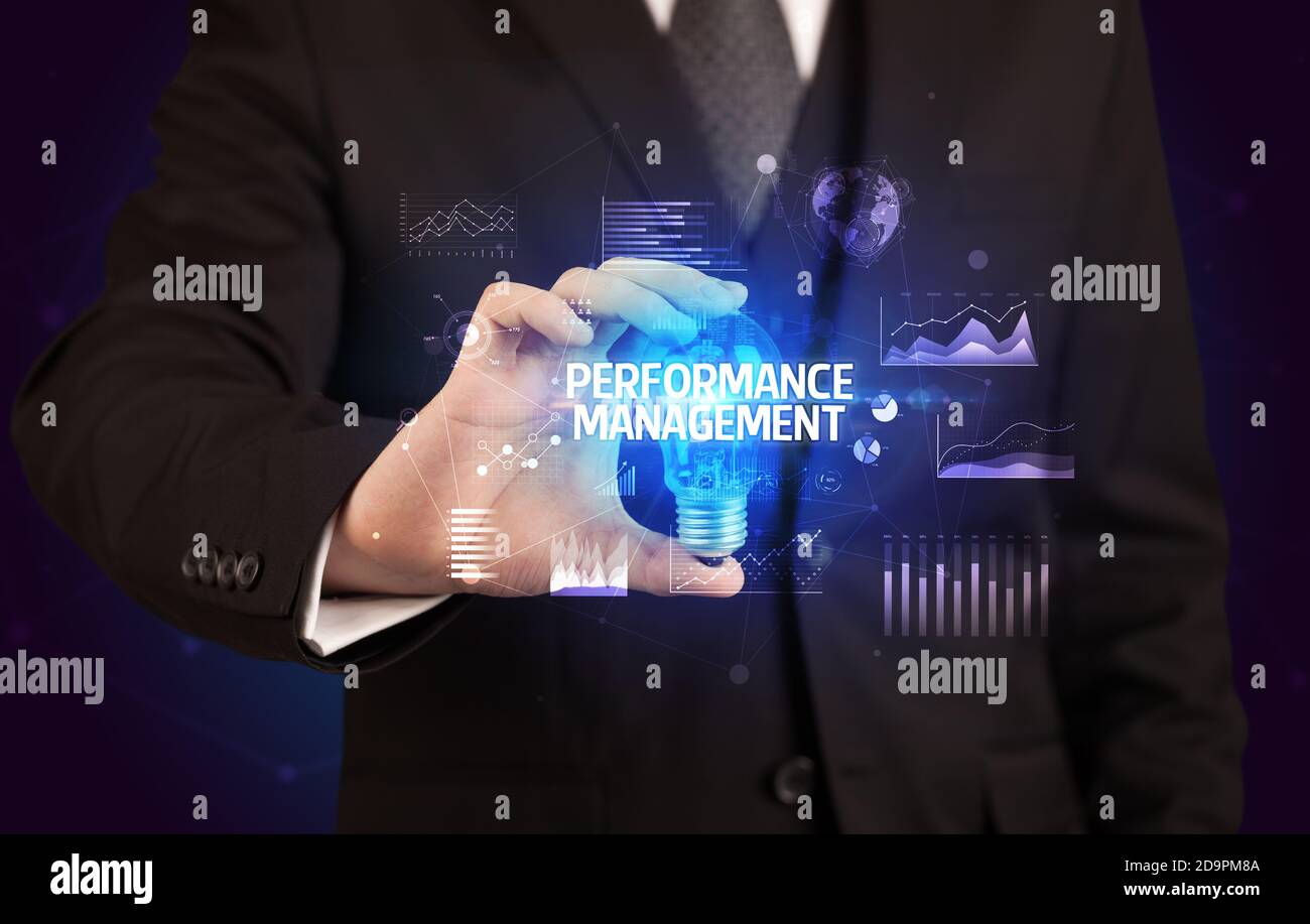 Businessman holding lightbulb with PERFORMANCE MANAGEMENT inscription ...