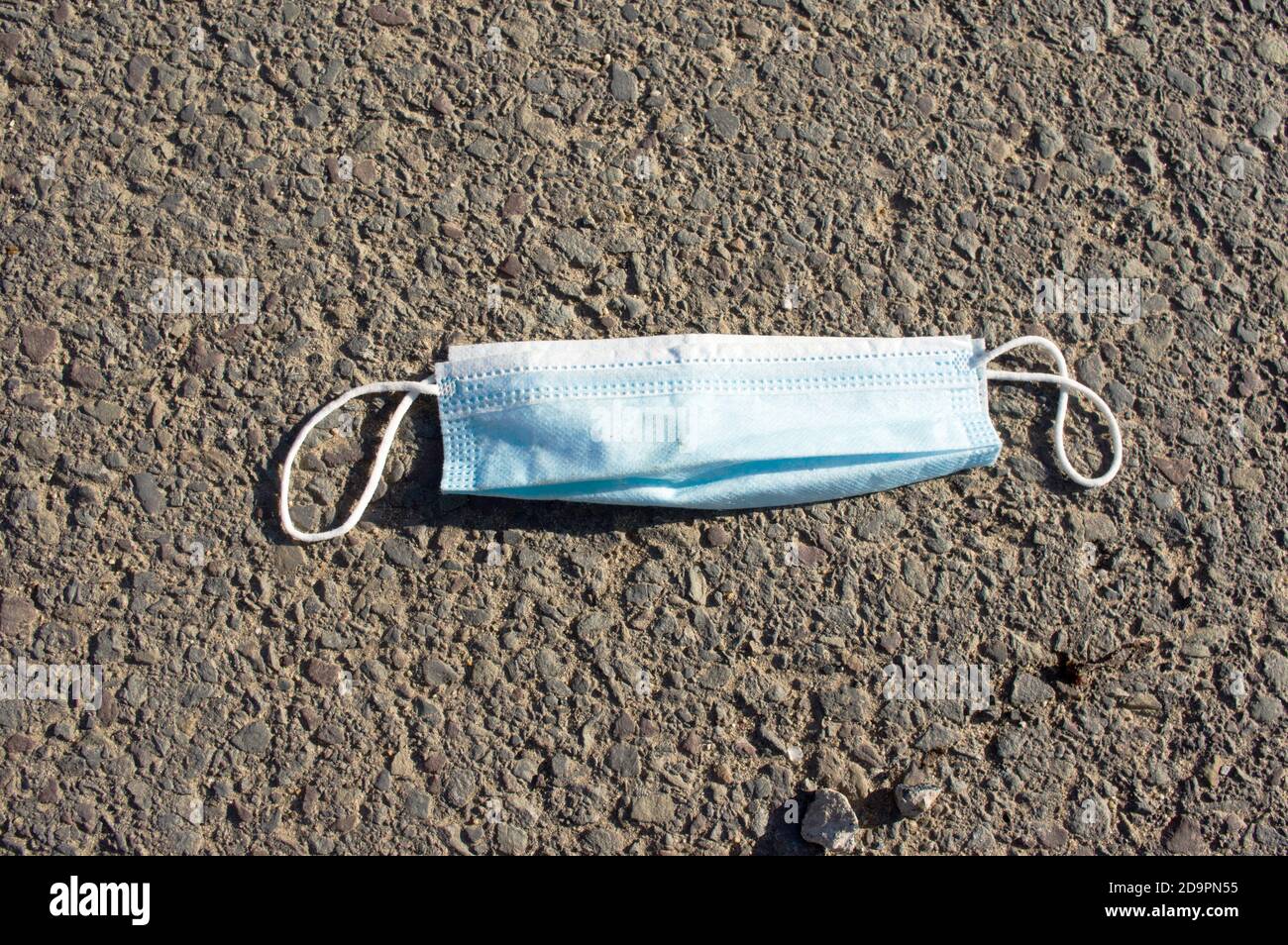 Pollution of used protective face mask on the street of black asphalt ...
