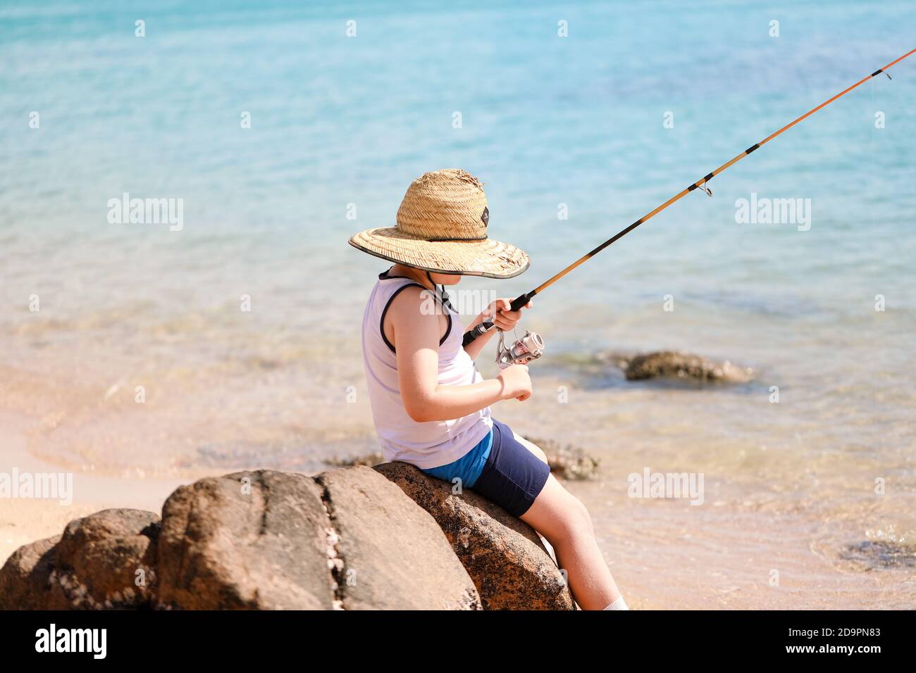 Boy sitting on rock fishing hi-res stock photography and images - Alamy