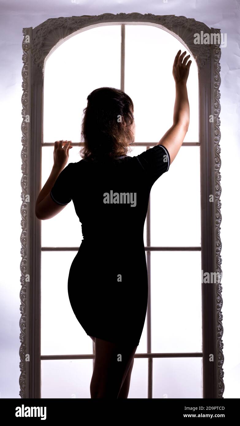 Woman's beautiful sihouette on white window background studio portrait ...