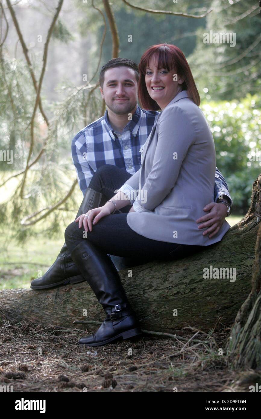 Young adults very much in love in parkland & woodland, cuddling ...