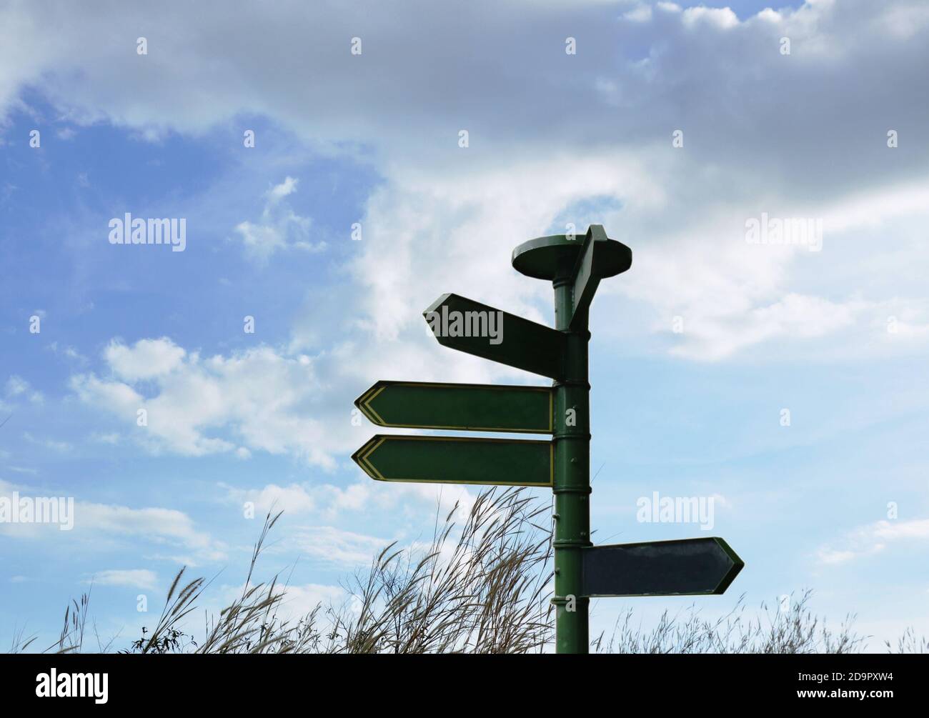 travel guide post on grass field and sky background Stock Photo - Alamy