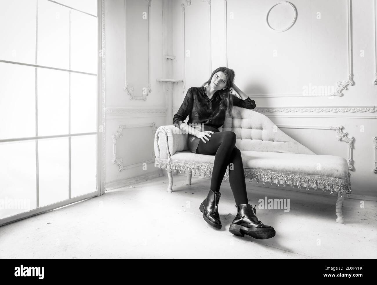 Studio portrait of young beautiful woman sitting on sofa Stock Photo ...
