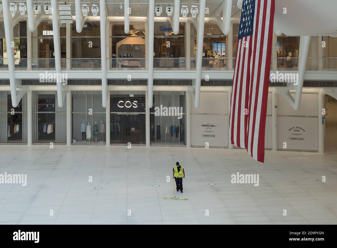 A custodian wearing a face mask performs his duties inside an empty ...
