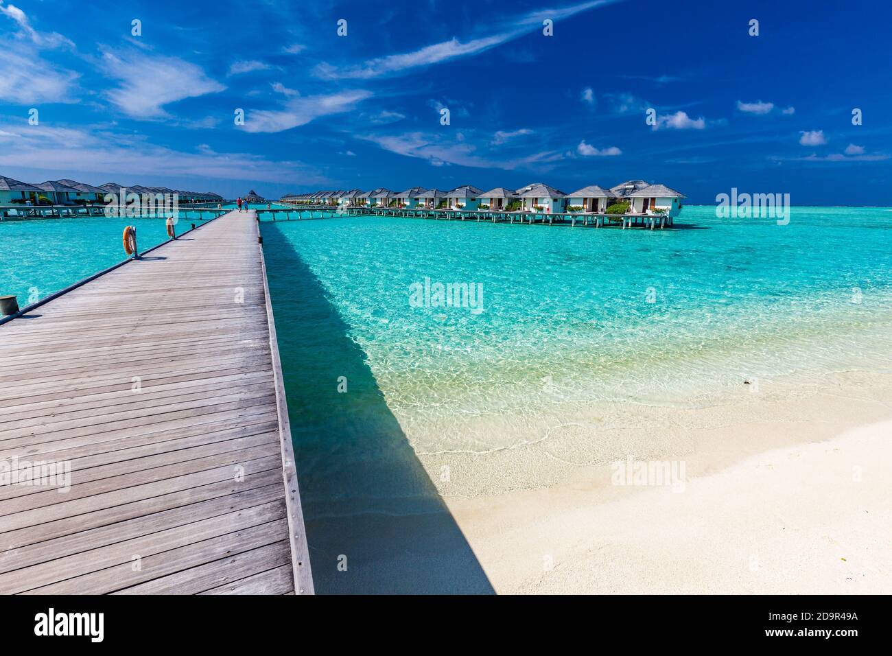 Jetty over swimming atoll and a tropical resort island in Maldives ...