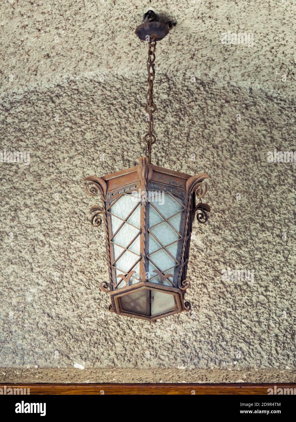 Vintage old lamp post hanging on the wall above the door entrance Stock ...