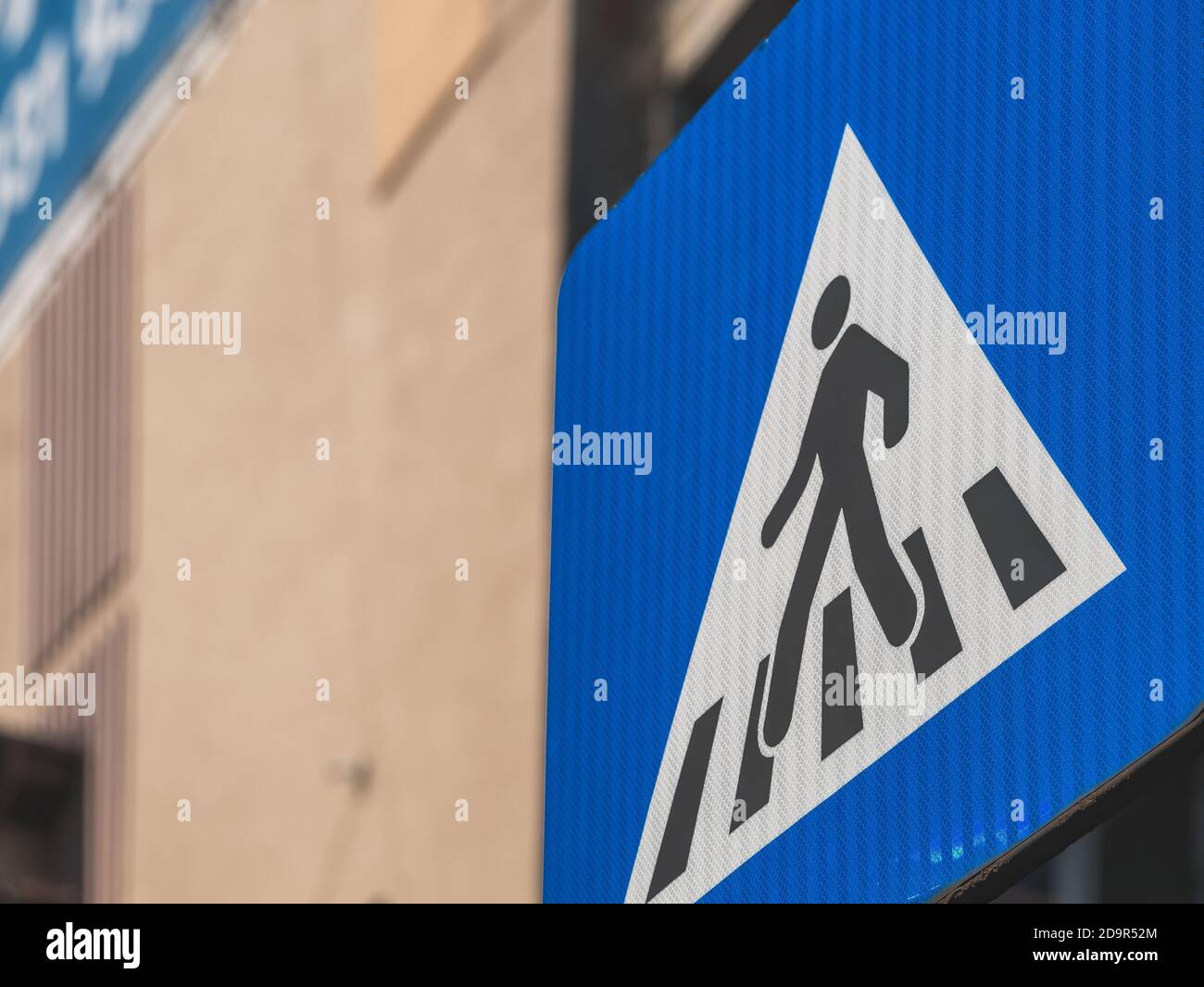 Pedestrian crossing traffic sign. Blue sign with a white triangle and a ...