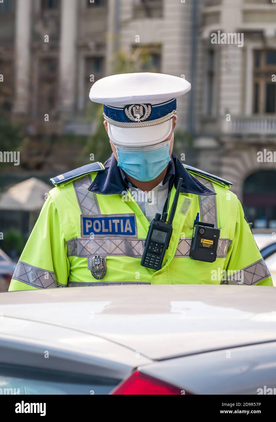 Close up with a romanian police officer in uniform wearing a face mask ...