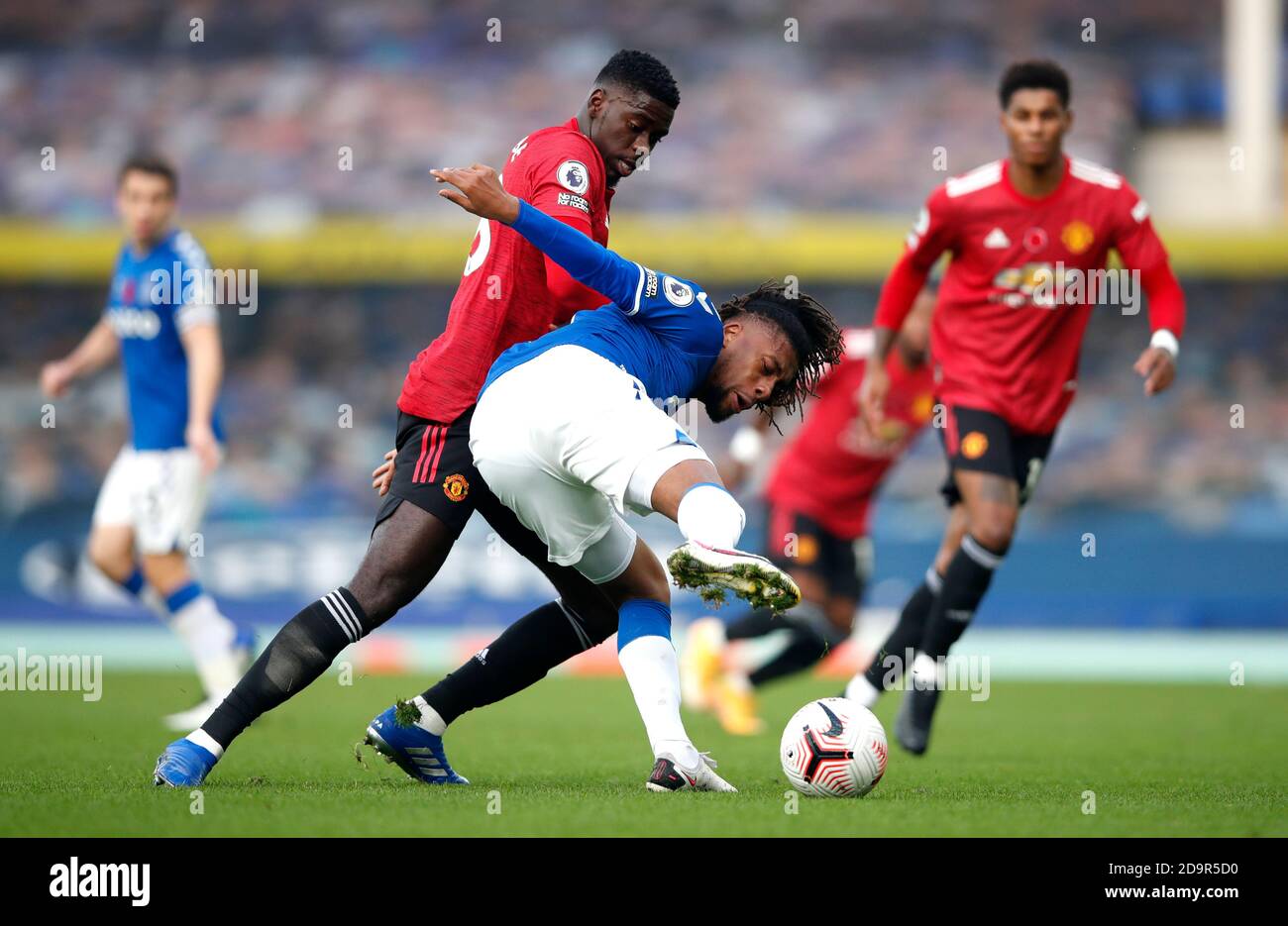 Everton's Alex Iwobi (centre) and Manchester United's Axel Tuanzebe ...