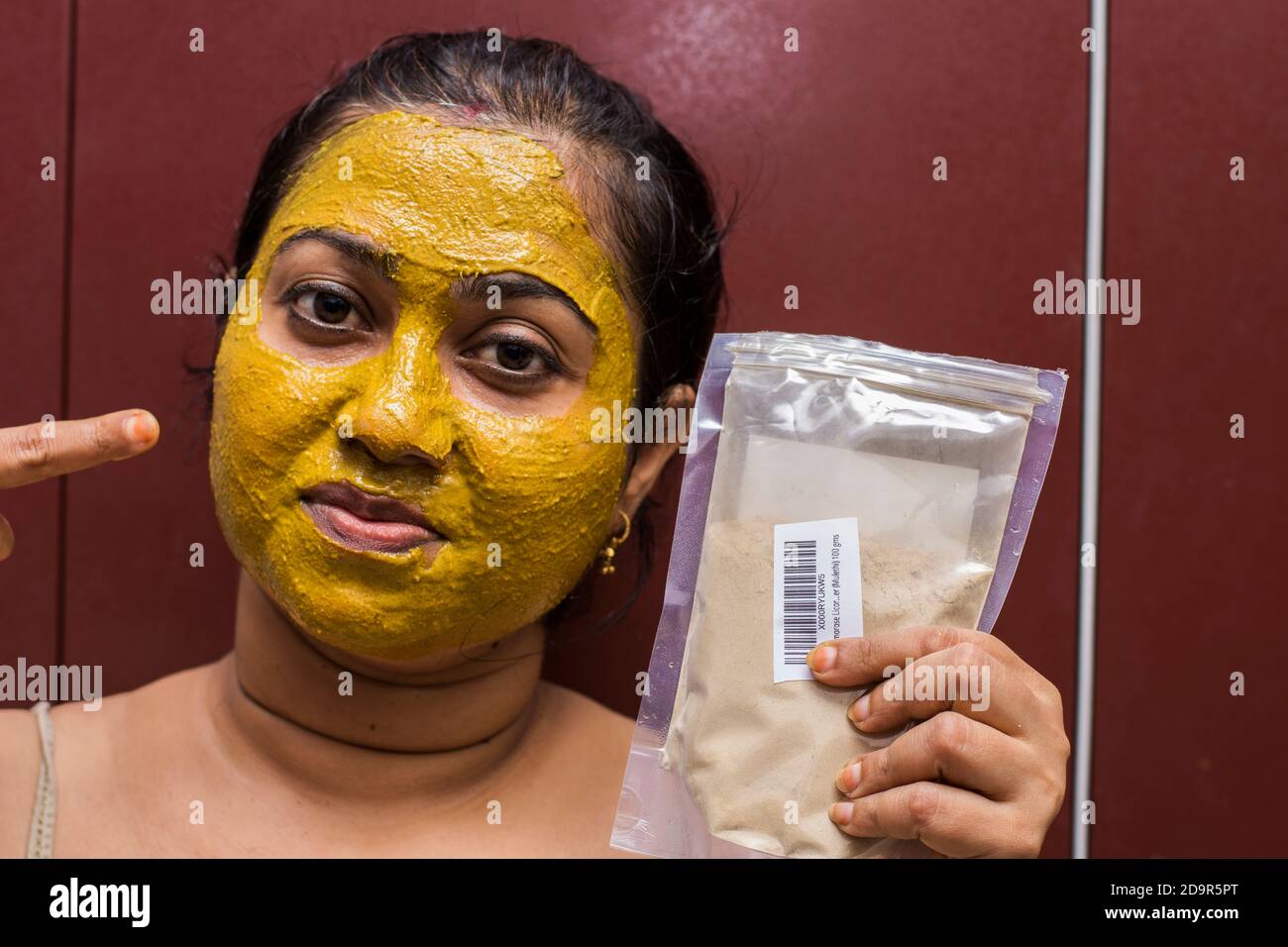 Close up of a beautiful woman with cosmetic facial green mask treatment ...