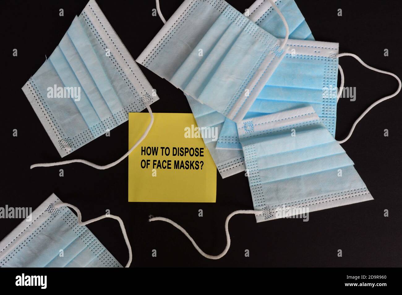 Warning and advice to dispose of used face mask written on yellow ...