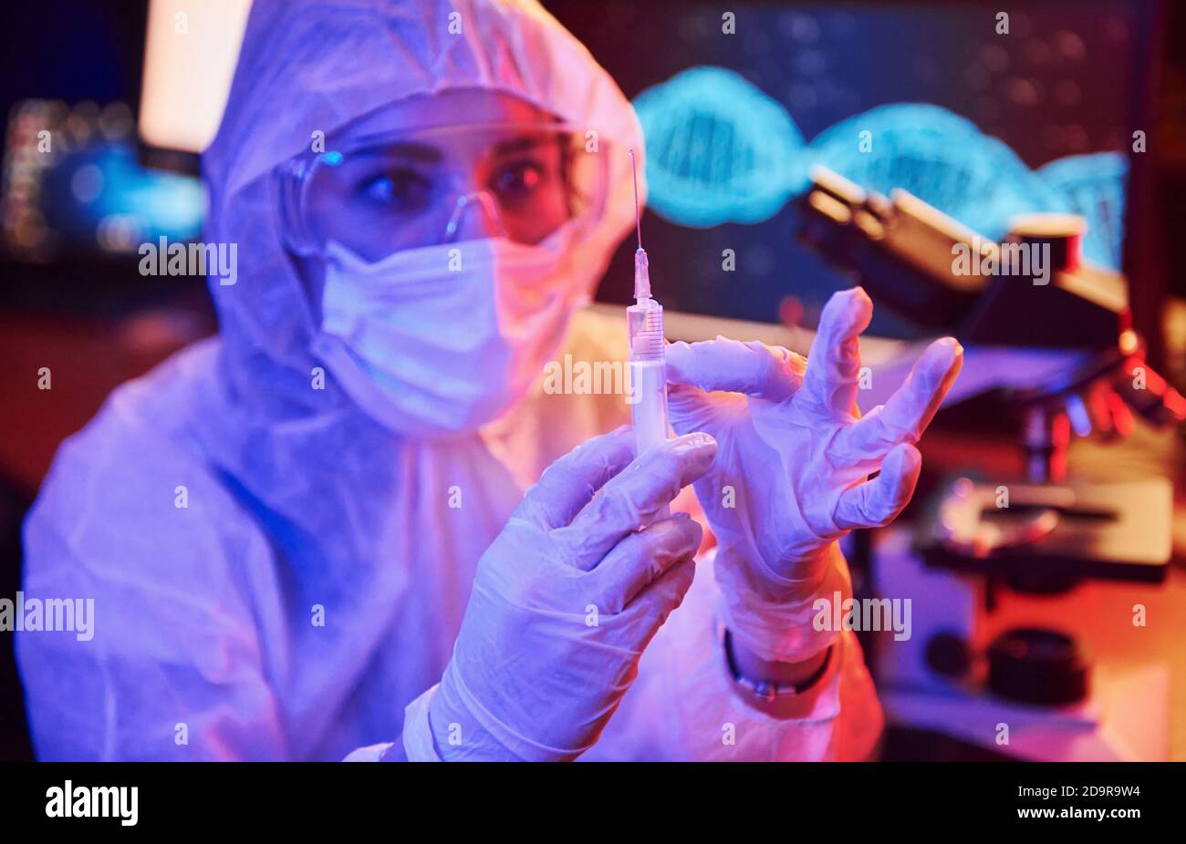 Nurse in mask and white uniform, holding syringe and sitting in neon ...