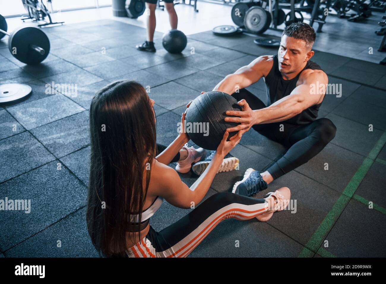 Young sportive people doing exercises and holding ball together in the ...