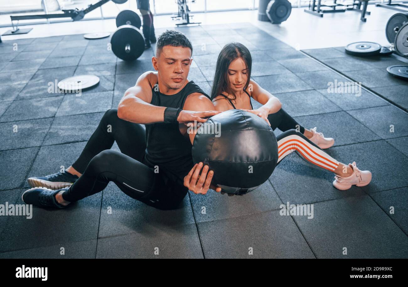 Young sportive people doing exercises and holding ball together in the ...