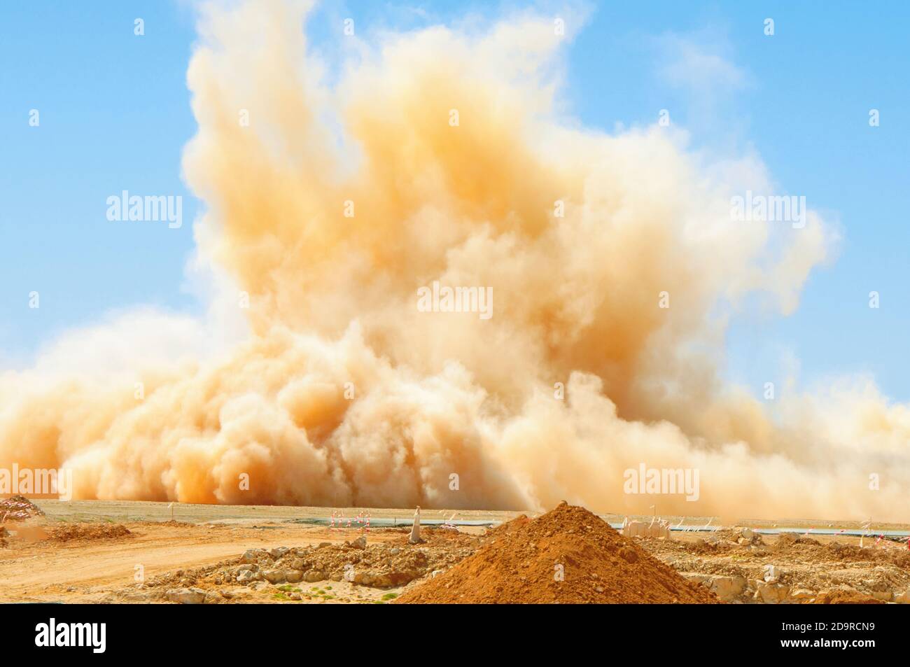 Dust storm in the desert during dynamite blast on the construction site ...