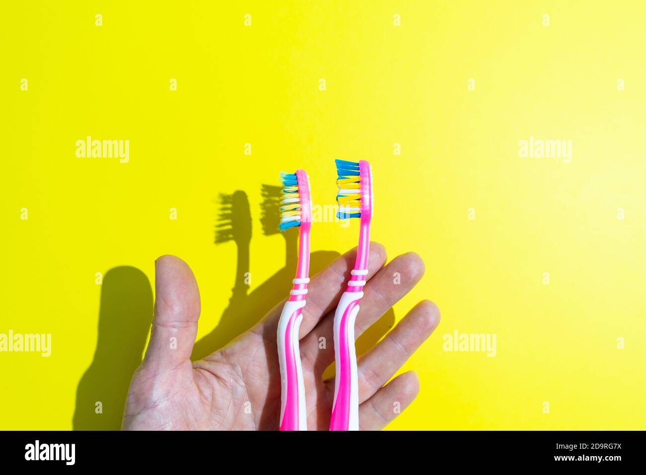 holding a toothbrush. old and new toothbrushes are located side by side ...