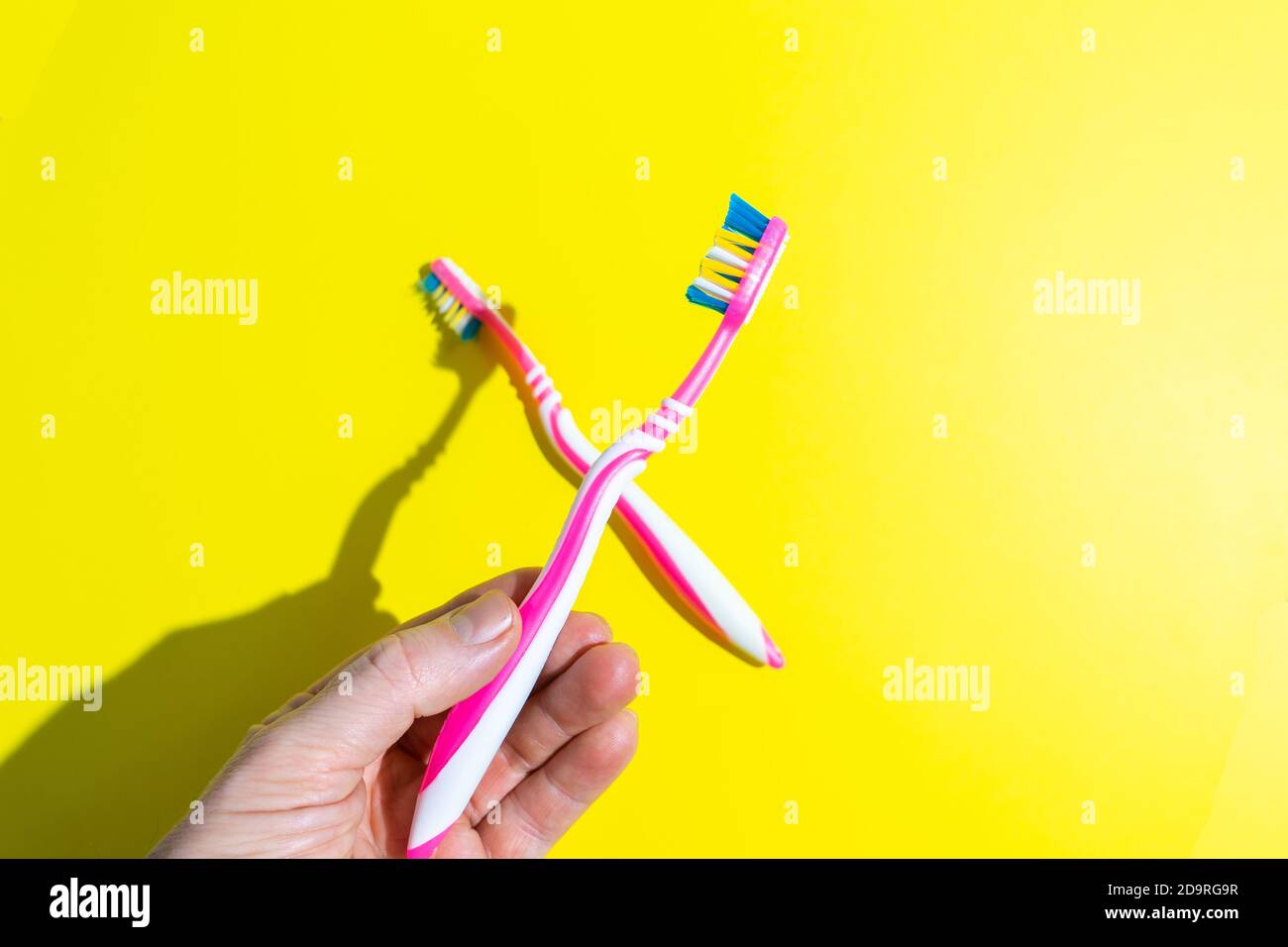holding a toothbrush. old and new toothbrushes are located side by side ...