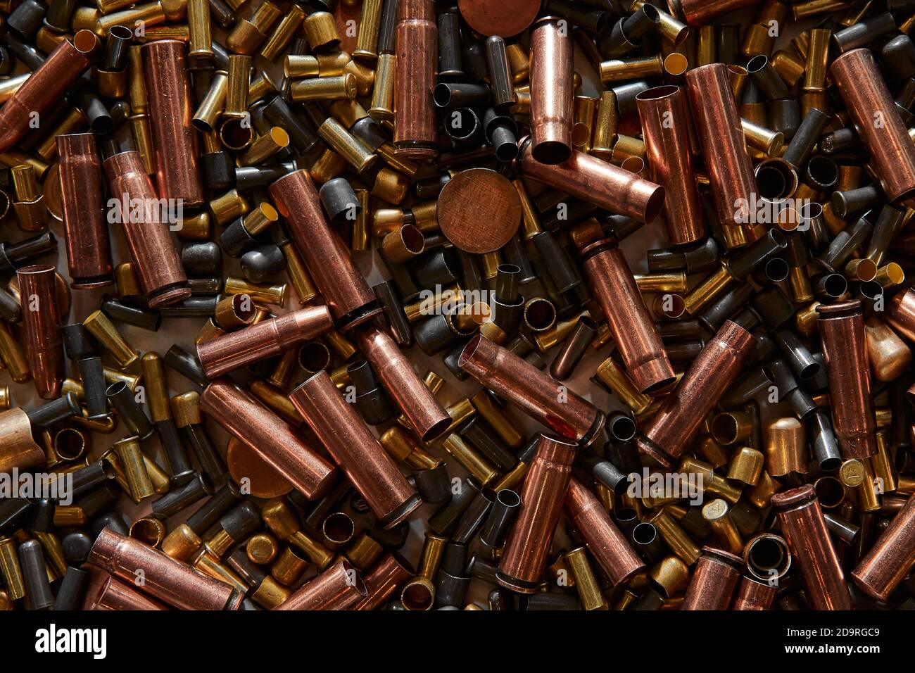Different size bullet shells on the black ground. War concept ...